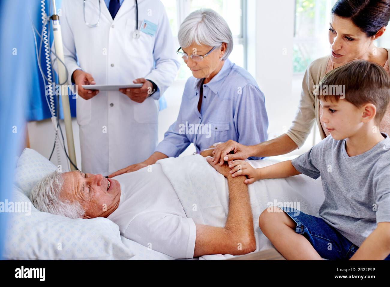 Lifting his spirits with a family visit. a sick man in a hospital bed ...