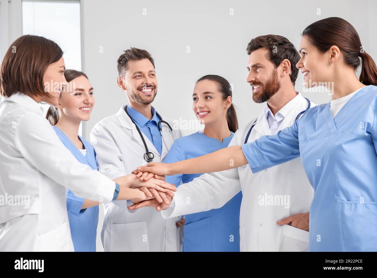 Team of medical doctors putting hands together indoors Stock Photo - Alamy