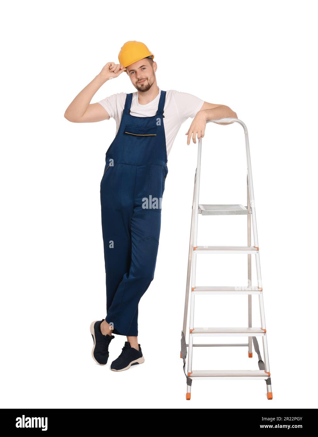 Worker in uniform and hard hat near metal ladder on white background ...