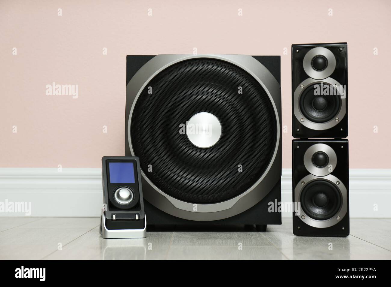 Modern powerful audio speaker system on floor near pink wall Stock ...