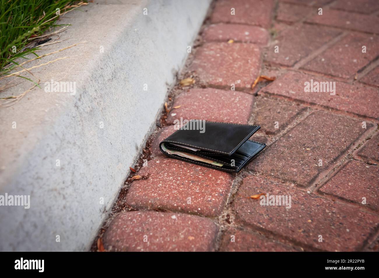Black wallet on pavement outdoors. Lost and found Stock Photo - Alamy