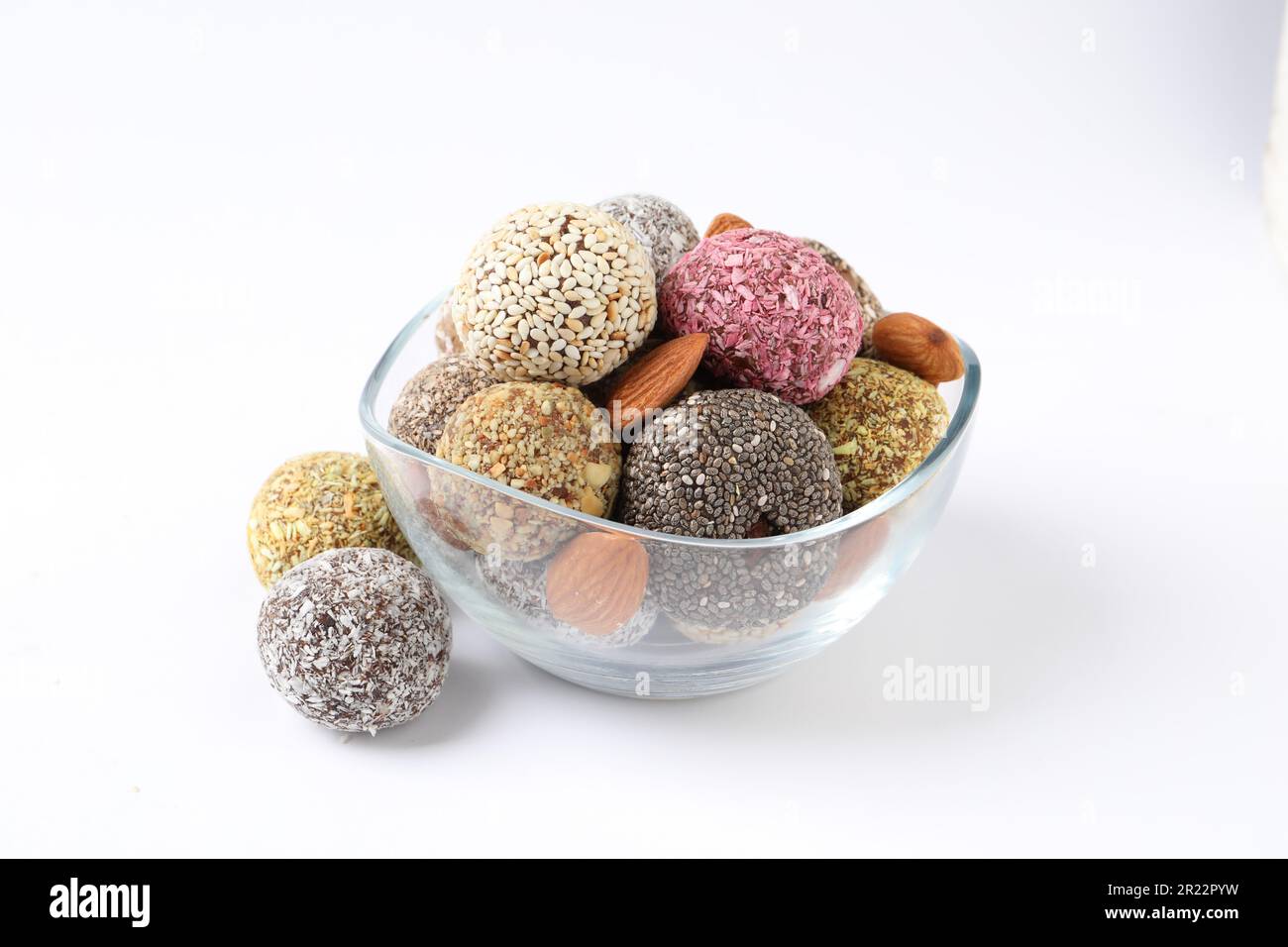 Different Delicious Vegan Candy Balls With Almonds On White Background