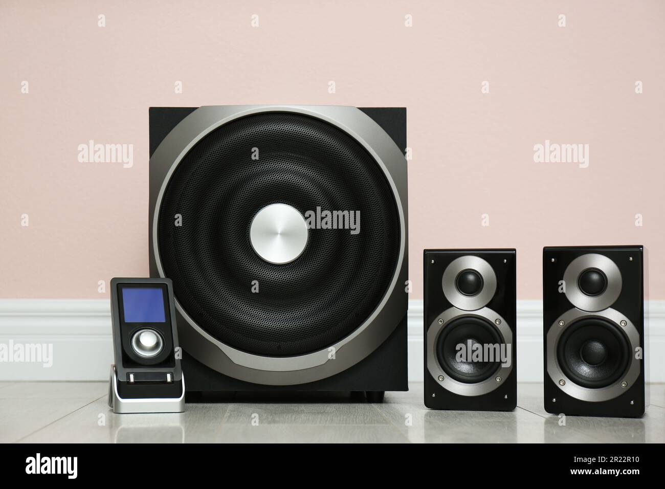 Modern powerful audio speaker system on floor near pink wall Stock ...