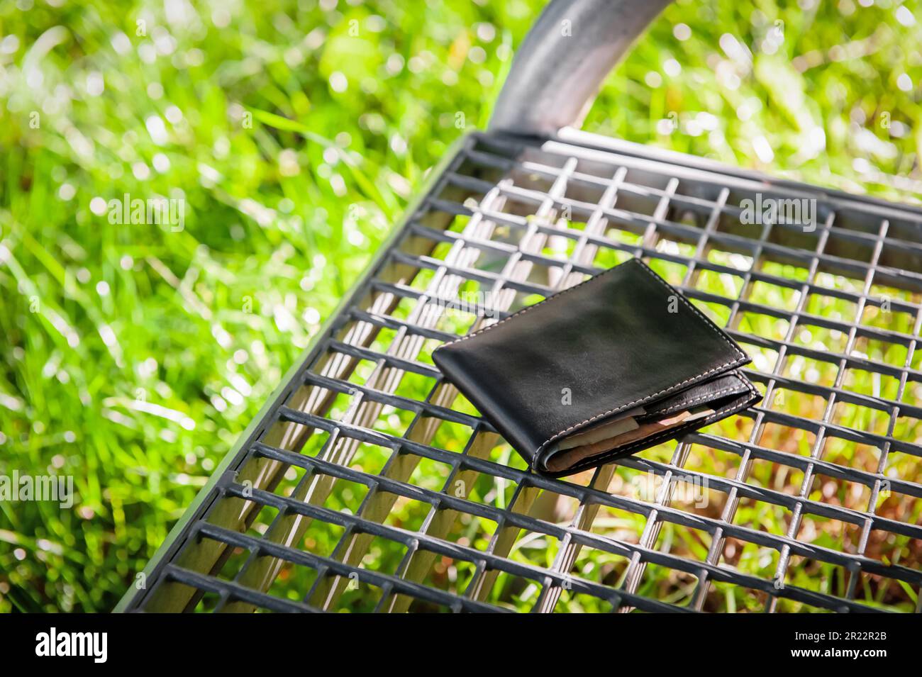 Black wallet on metal bench outdoors, space for text. Lost and found ...