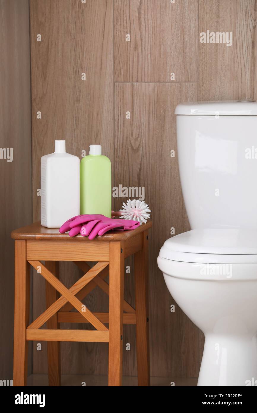 Cleaning supplies on stool near toilet bowl indoors Stock Photo - Alamy