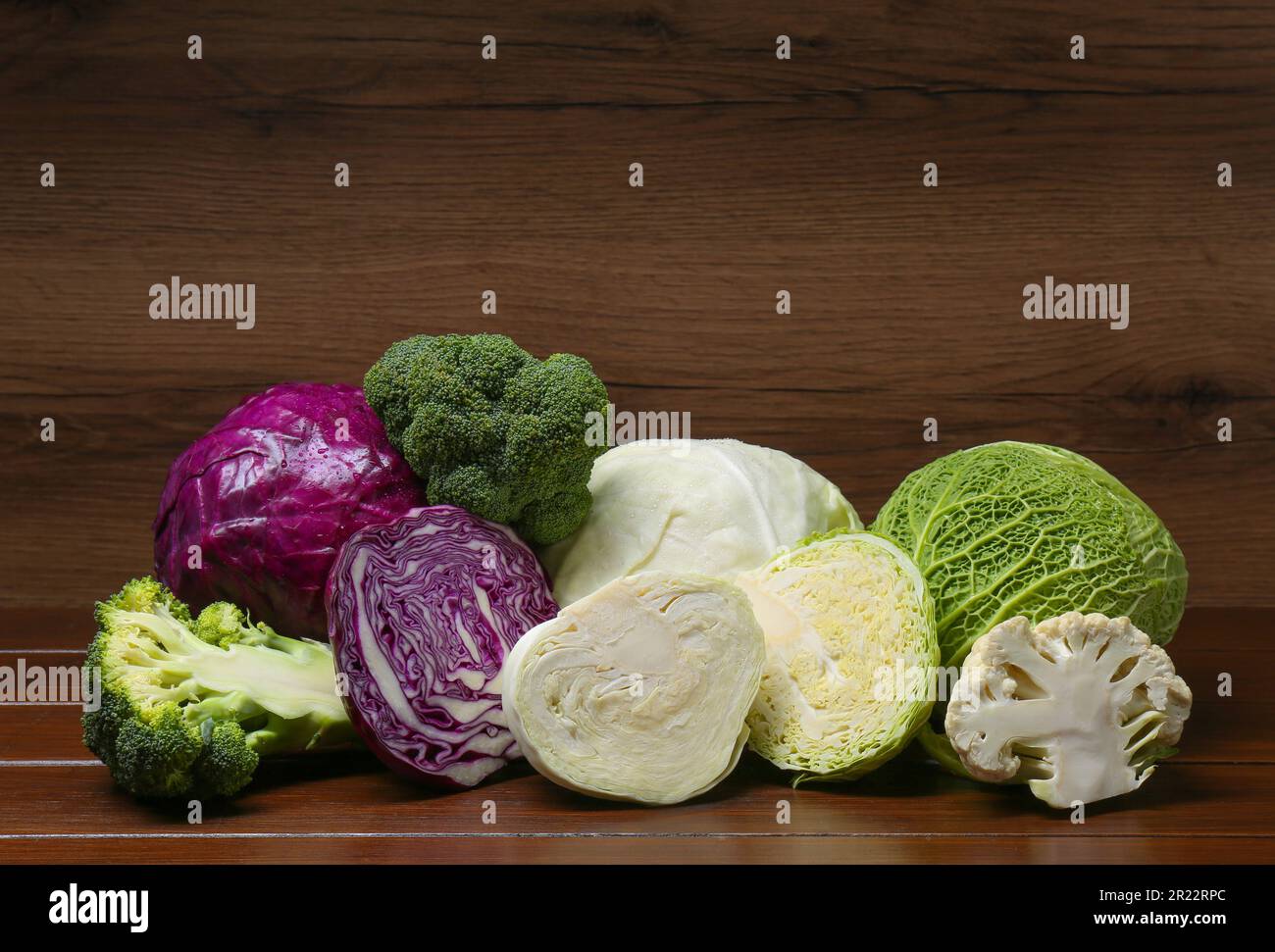 Different types of cabbage on wooden table Stock Photo - Alamy