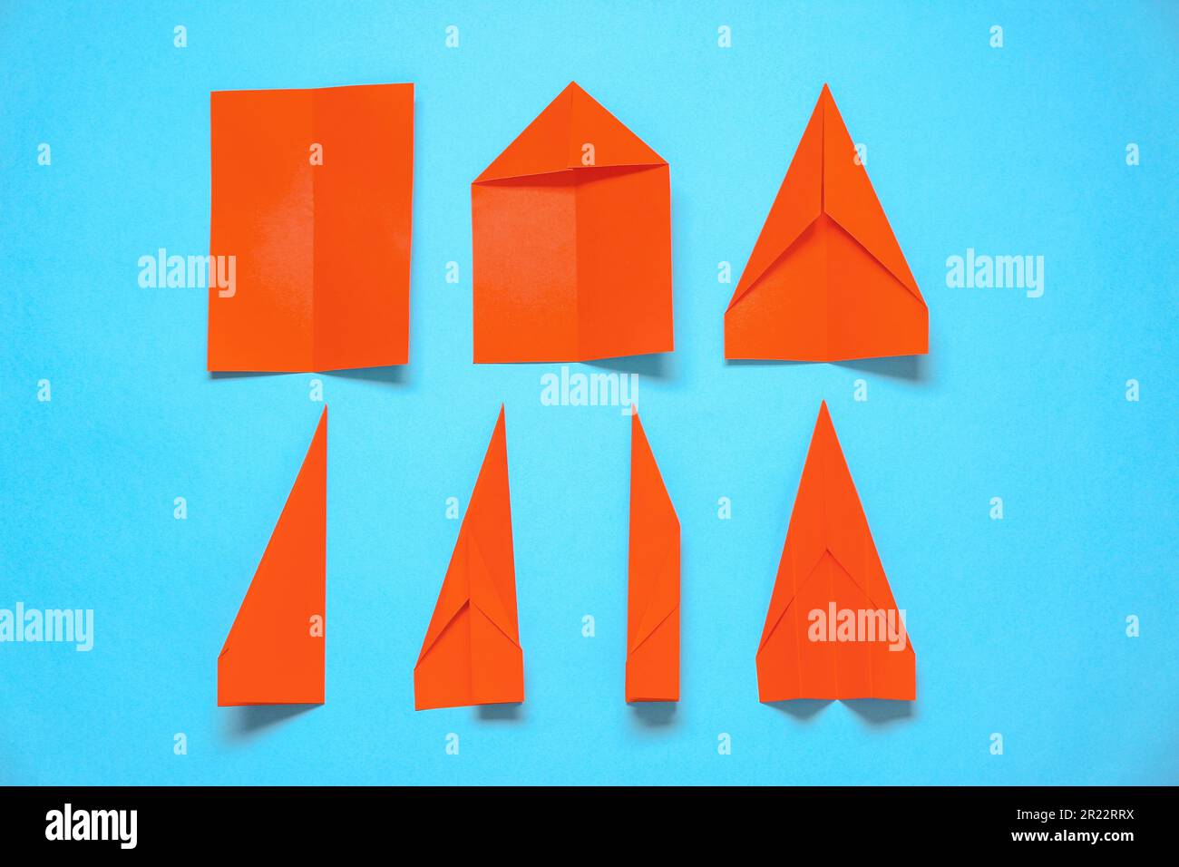 Making paper plane step by step. Instruction on light blue background ...