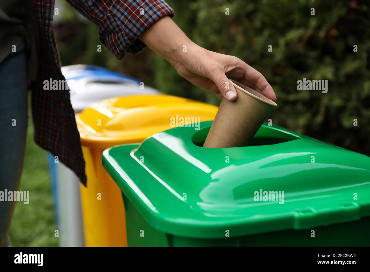 Woman throwing coffee cup into recycling bin outdoors, closeup Stock ...