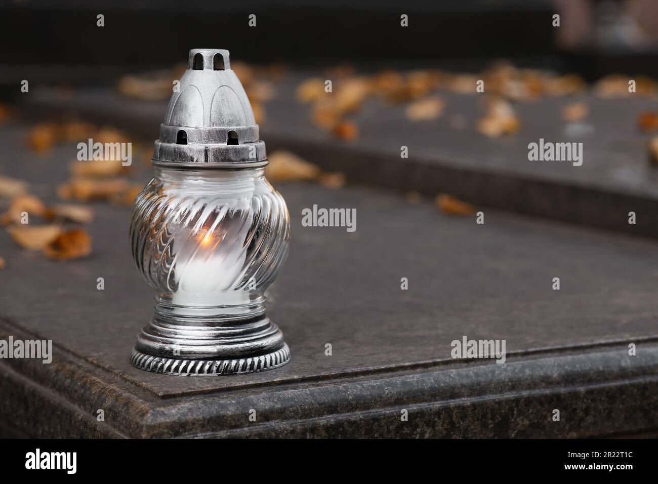 Grave lantern with burning candle on granite surface in cemetery, space for text Stock Photo - Alamy