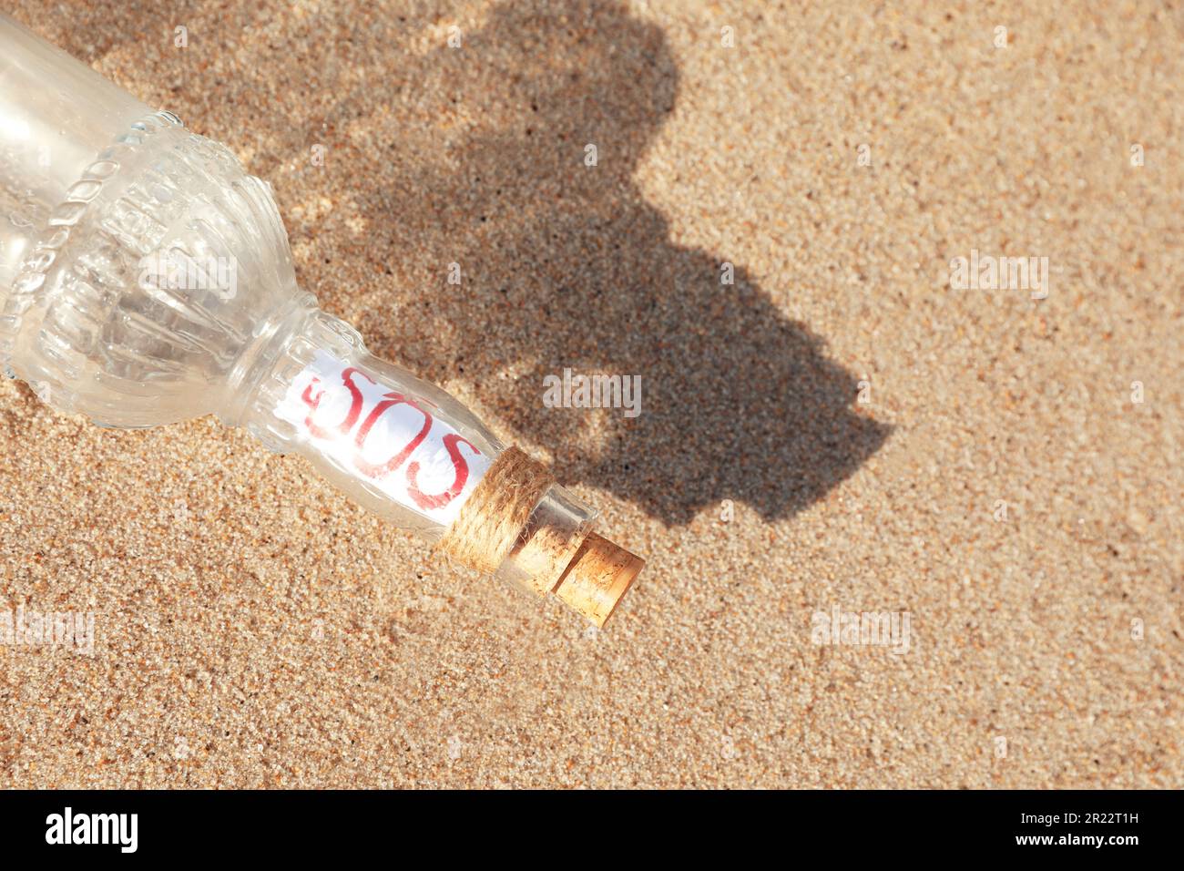 Glass bottle with SOS message on sand, top view Stock Photo - Alamy