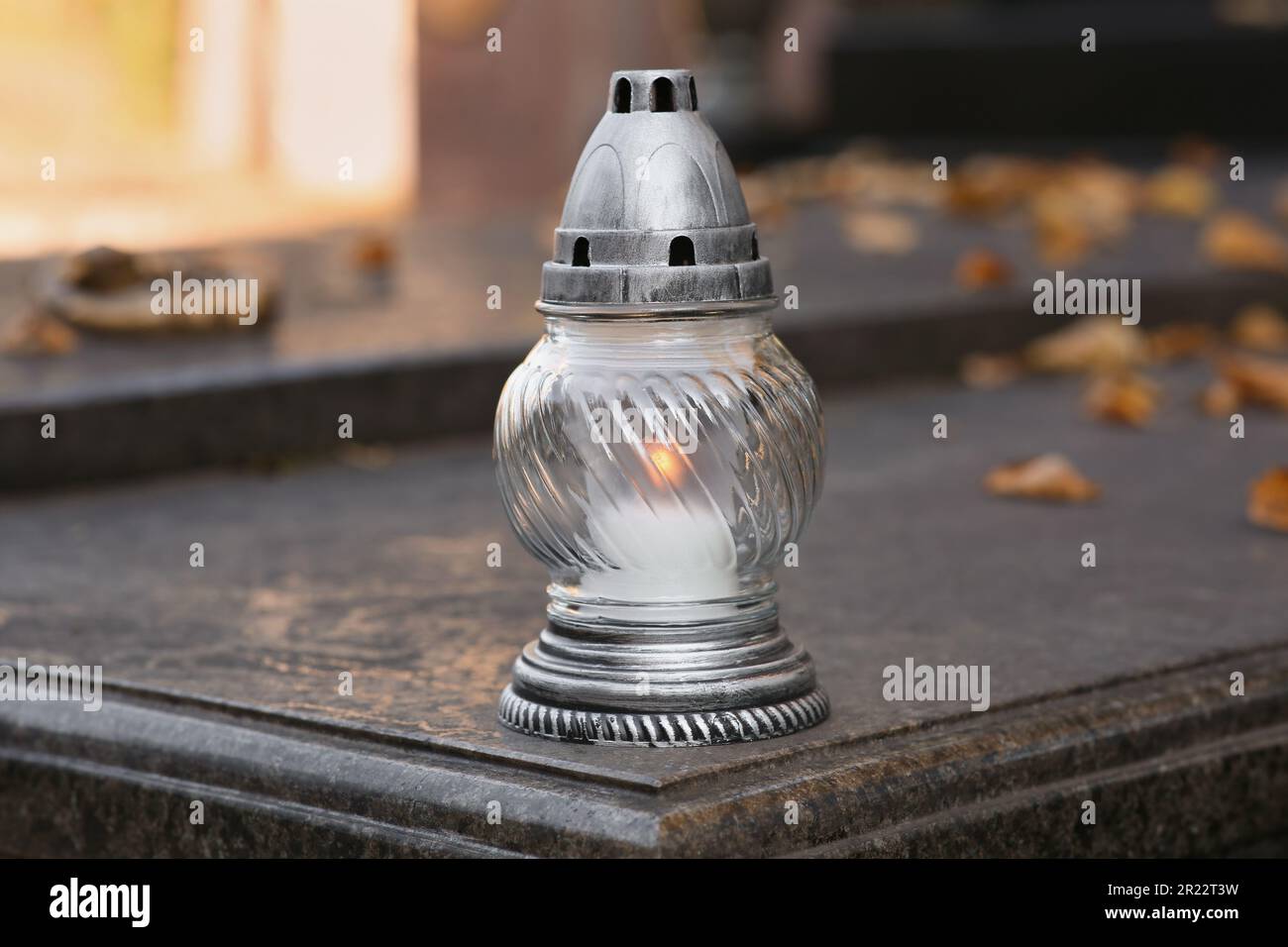 Grave lantern with burning candle on granite surface in cemetery Stock Photo - Alamy