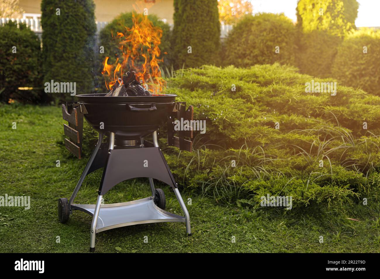 Portable barbecue grill with fire flames outdoors. Space for text Stock ...