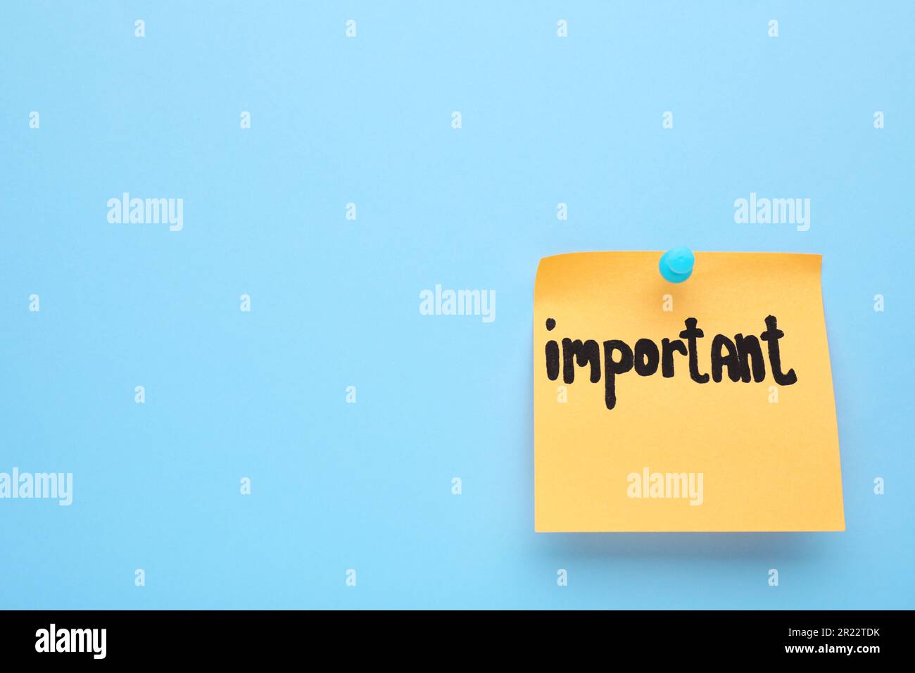 Paper note with word Important pinned on light blue background, space ...