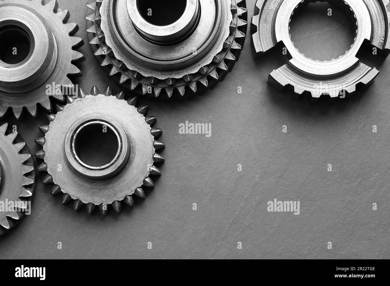 Different stainless steel gears on grey background, flat lay. Space for ...