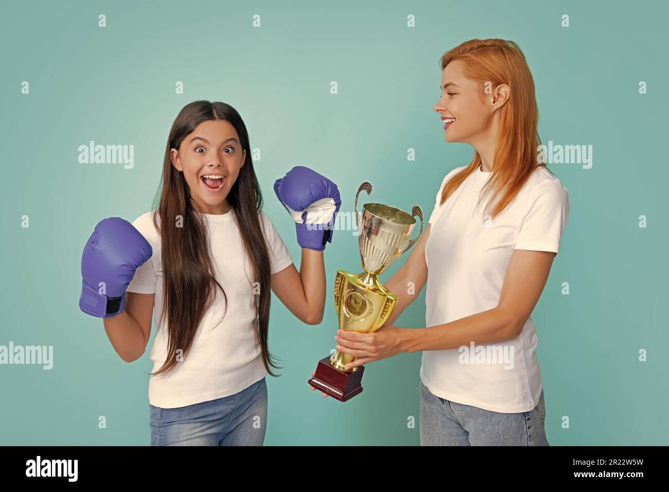 Mommy and teenager child daughter holding winning prize, showing trophy ...