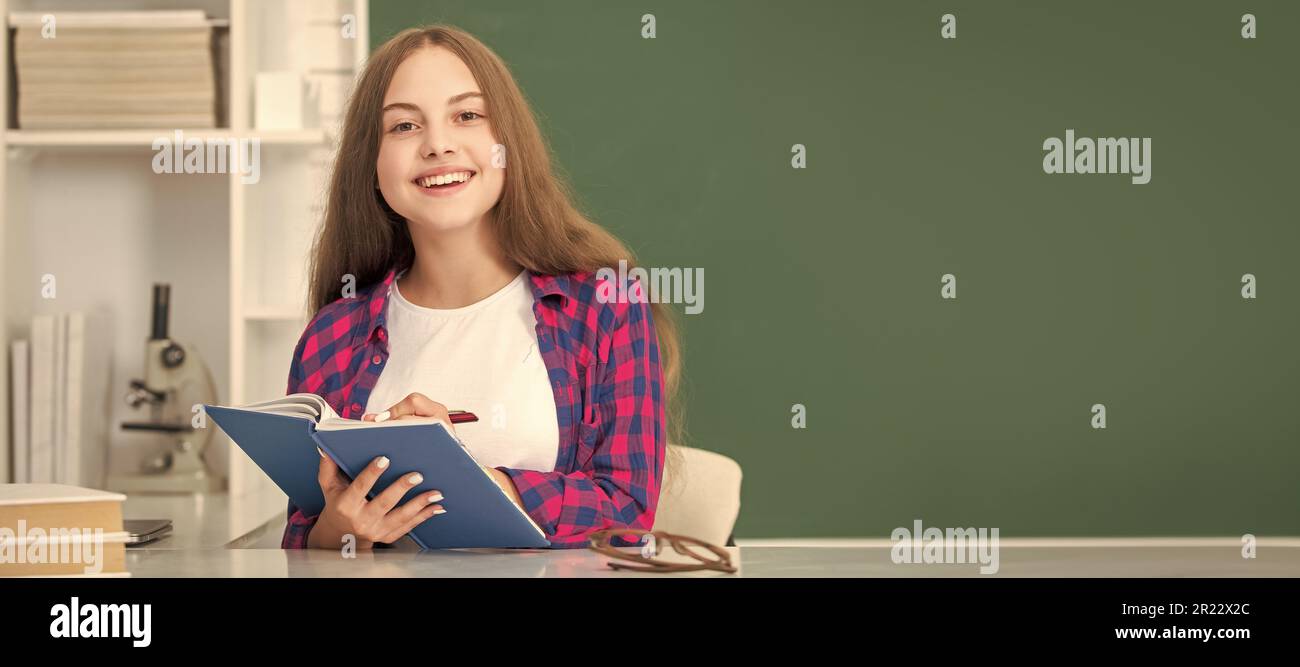 happy schoolgirl with copybook. child making notes in notebook. back to ...
