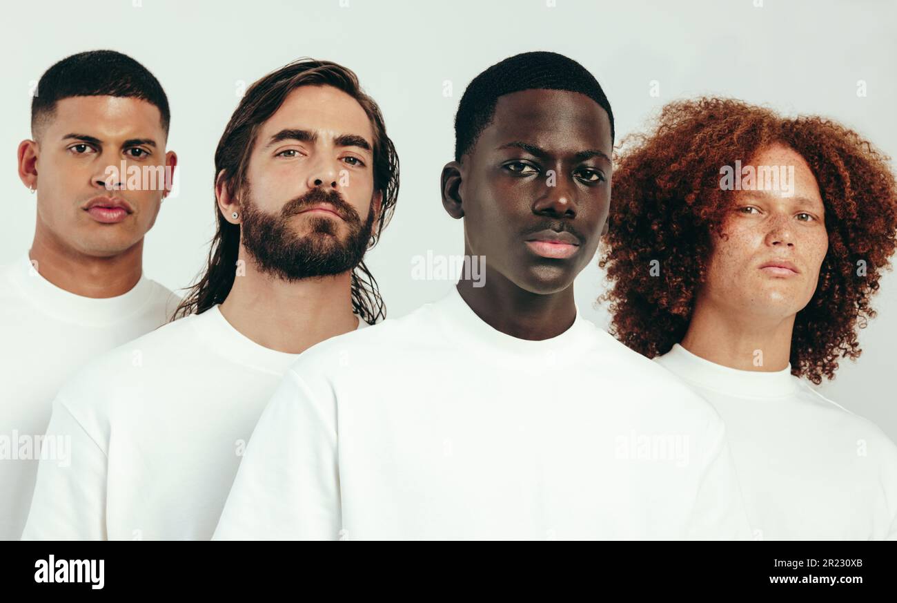 Group of young men with unique skin types standing together in a studio ...