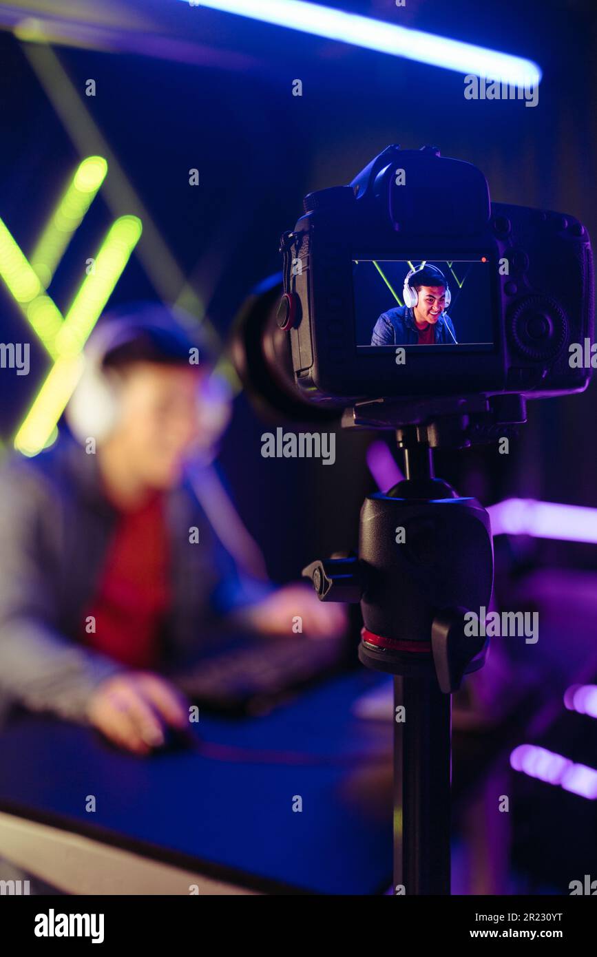 Streaming live to a virtual audience, a gamer sits in front of his ...