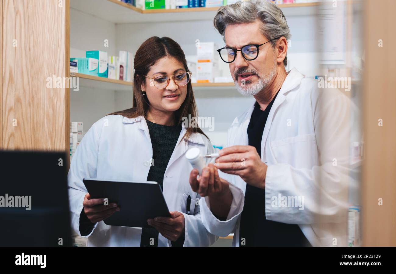 Healthcare providers filling online prescriptions in a pharmacy. Two ...