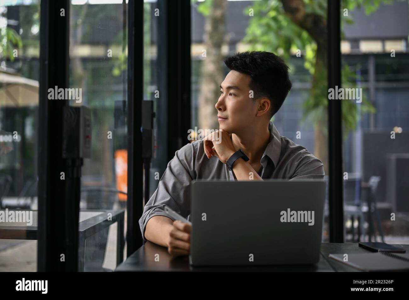 Inspired and handsome millennial Asian businessman thinking and ...