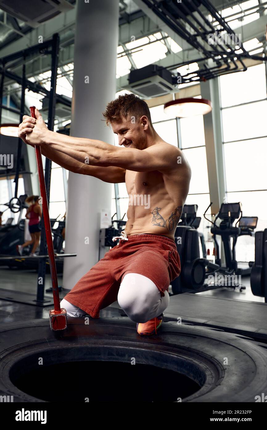 Strength concept. Male athlete using hammer during fitness workout ...