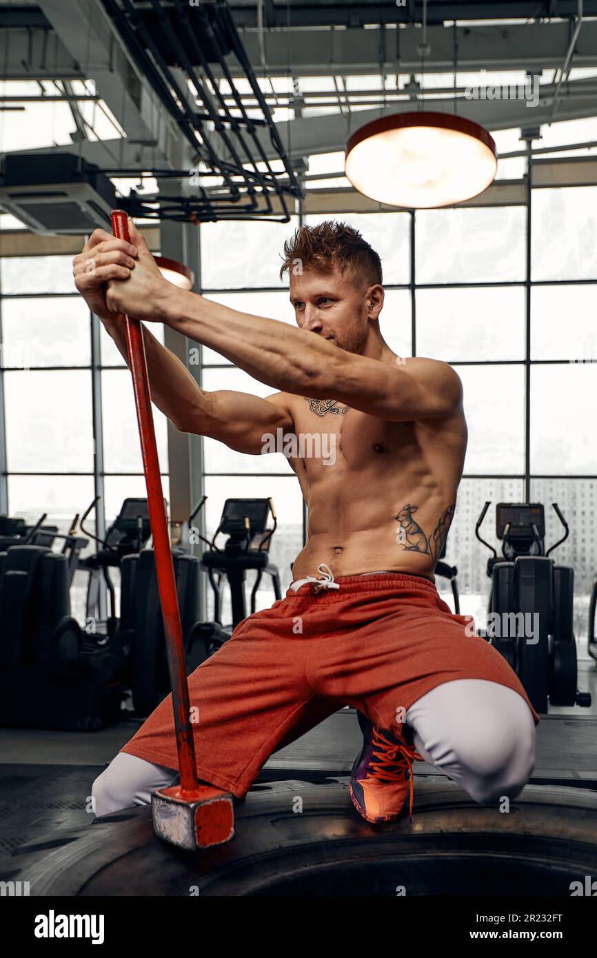 Strength concept. Male athlete using hammer during fitness workout ...