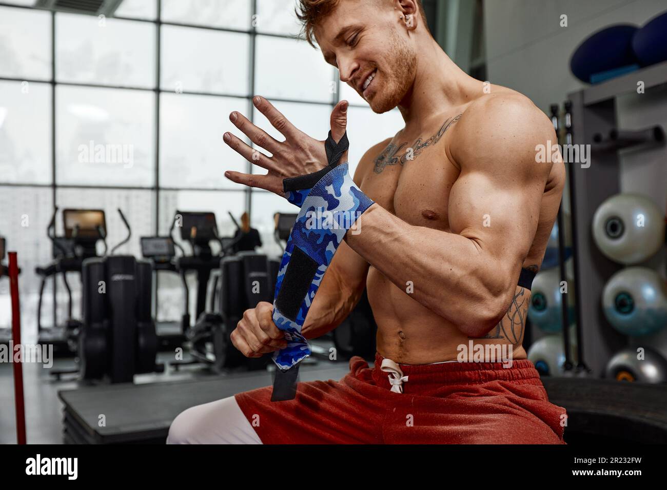 A beautiful athlete boxer, wraps his hands on sports bandages for ...