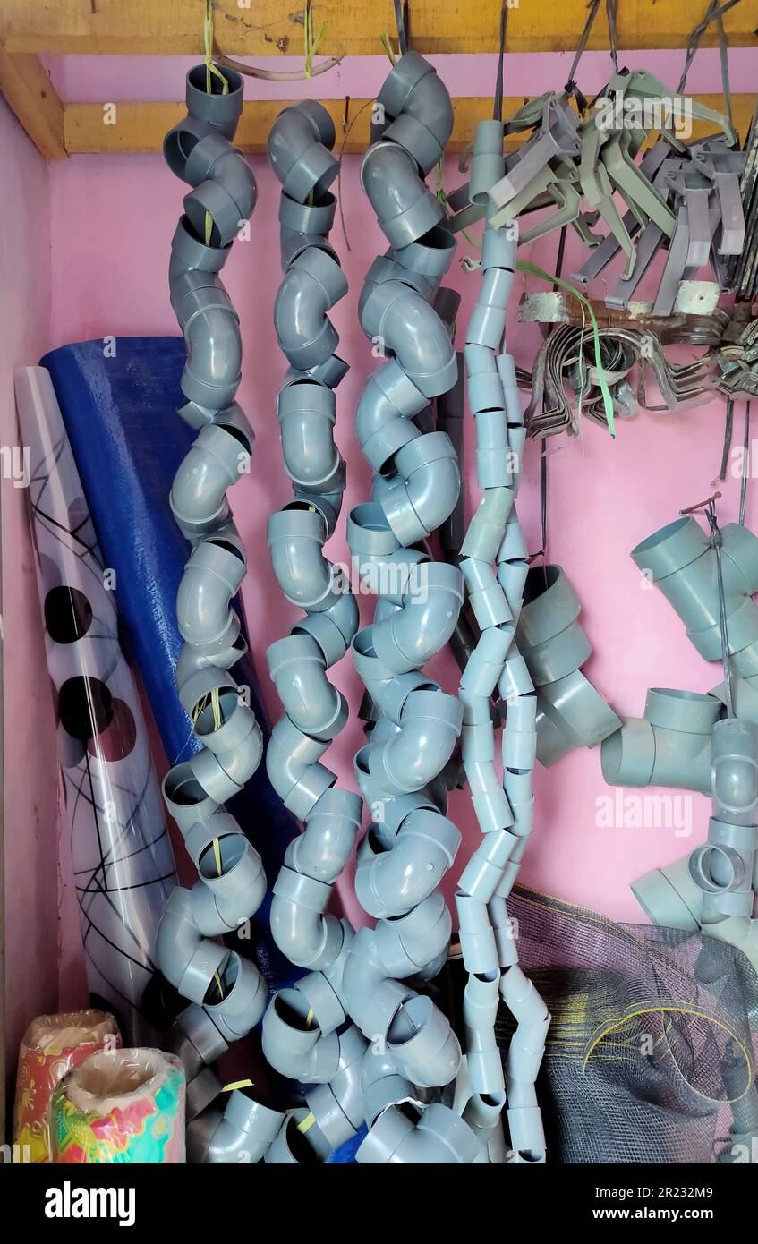 Some piles of pipes and pipe joints are in a material store, which is ...