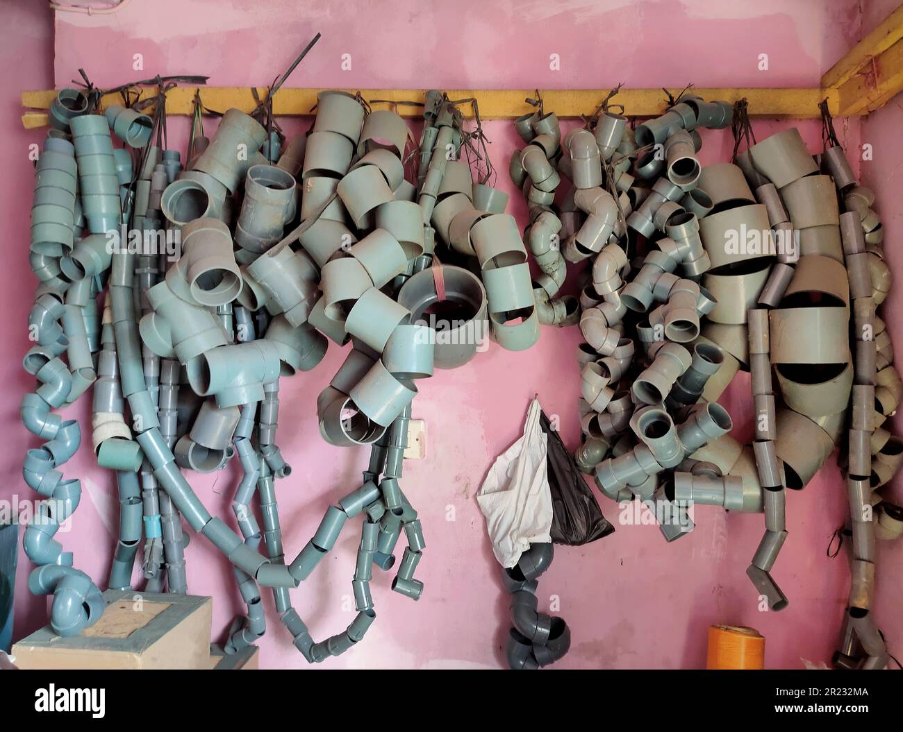 Some piles of pipes and pipe joints are in a material store, which is ...