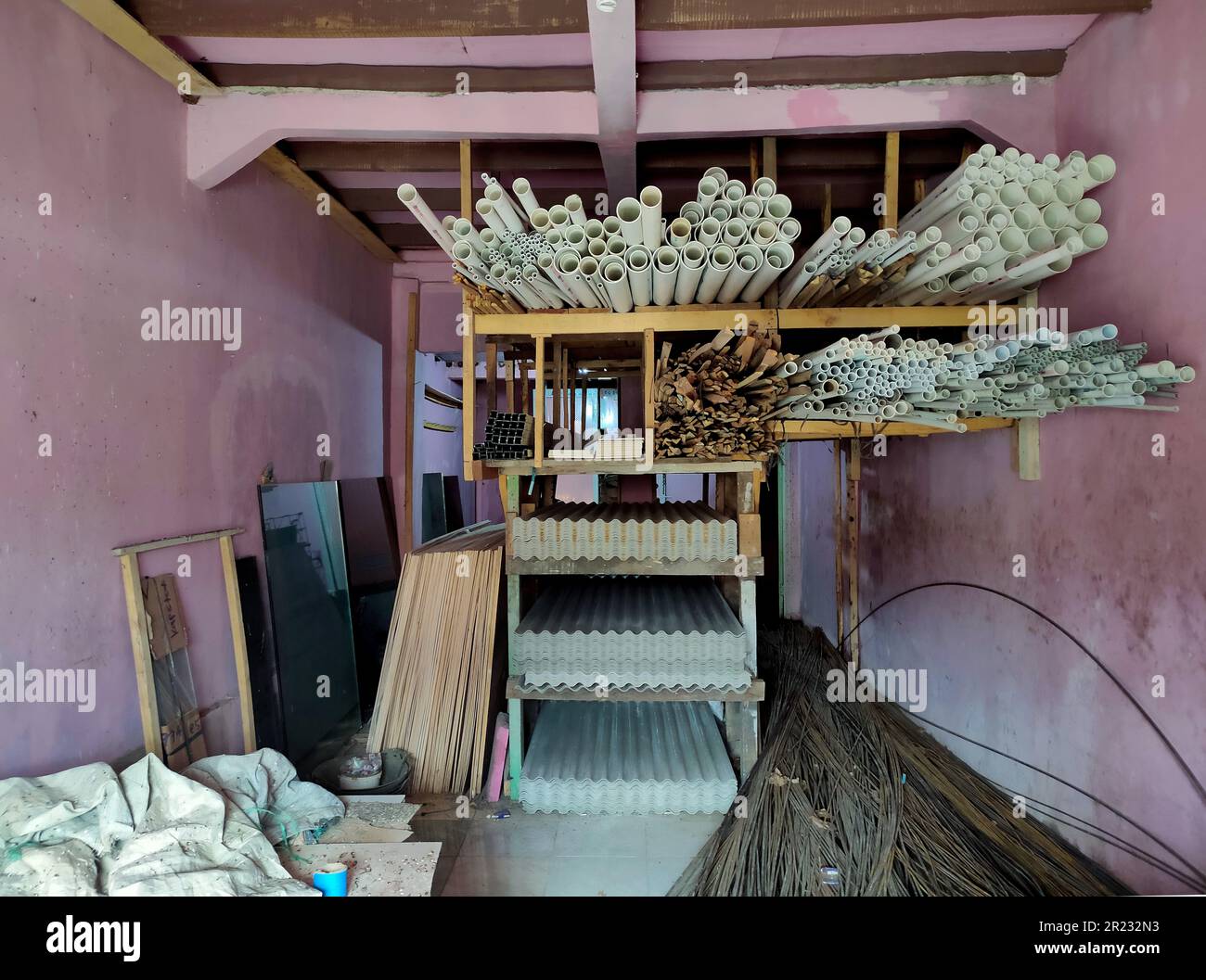 Some piles of pipes and pipe joints are in a material store, which is ...