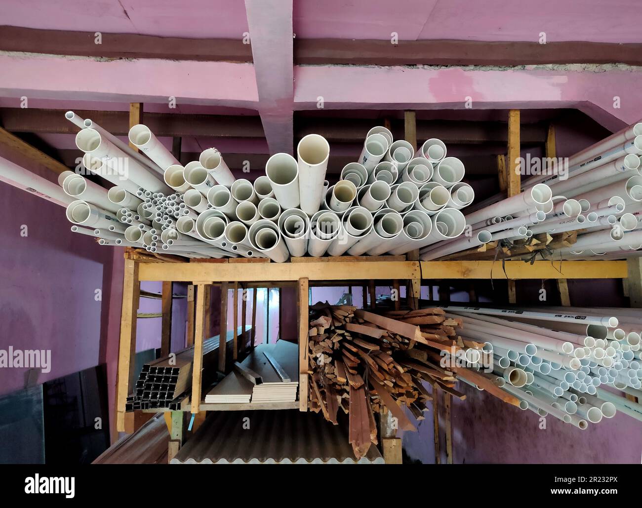 Some piles of pipes and pipe joints are in a material store, which is ...