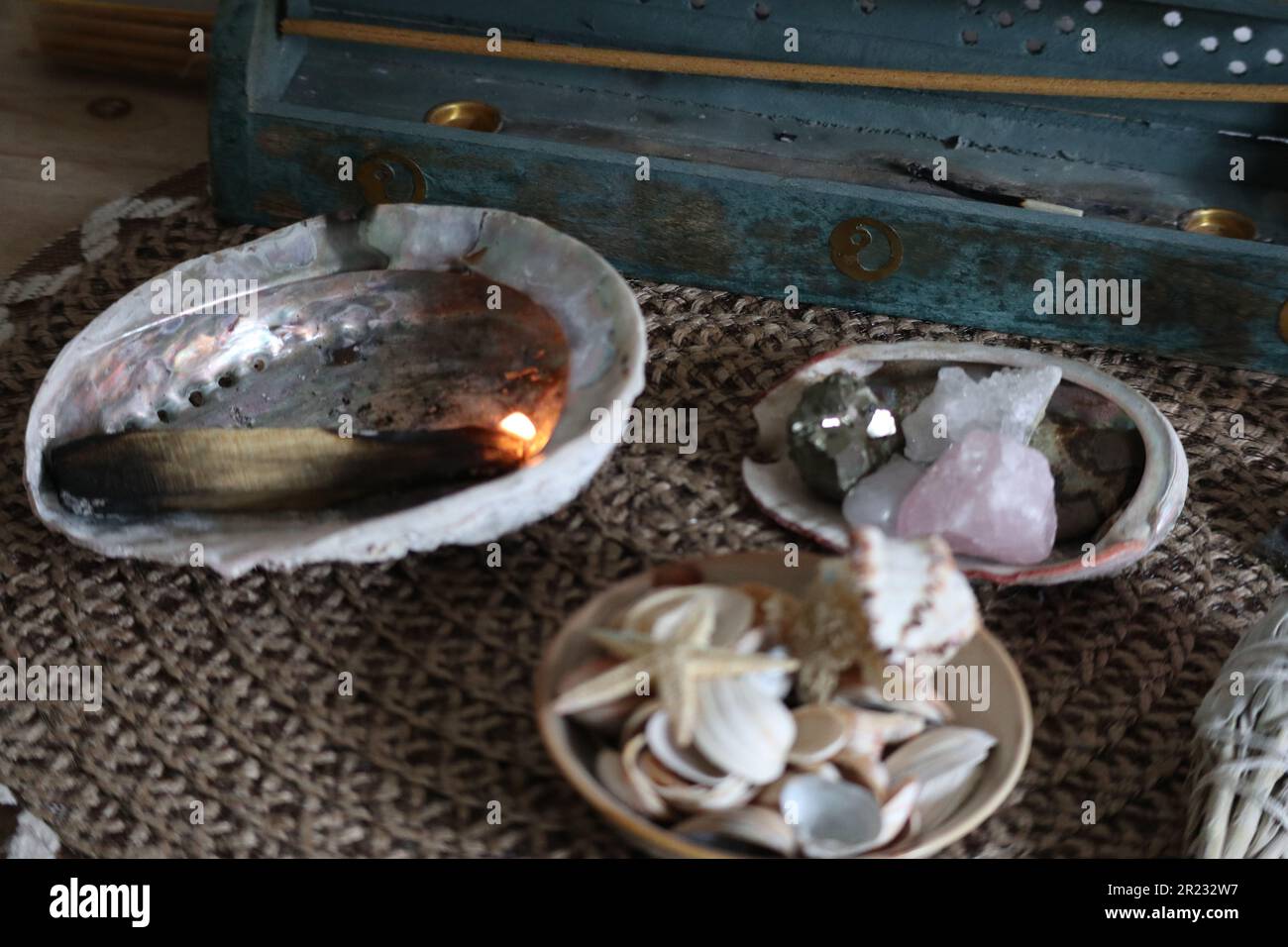 A knitted rug with bowls with shells and stones and a burning wooden ...