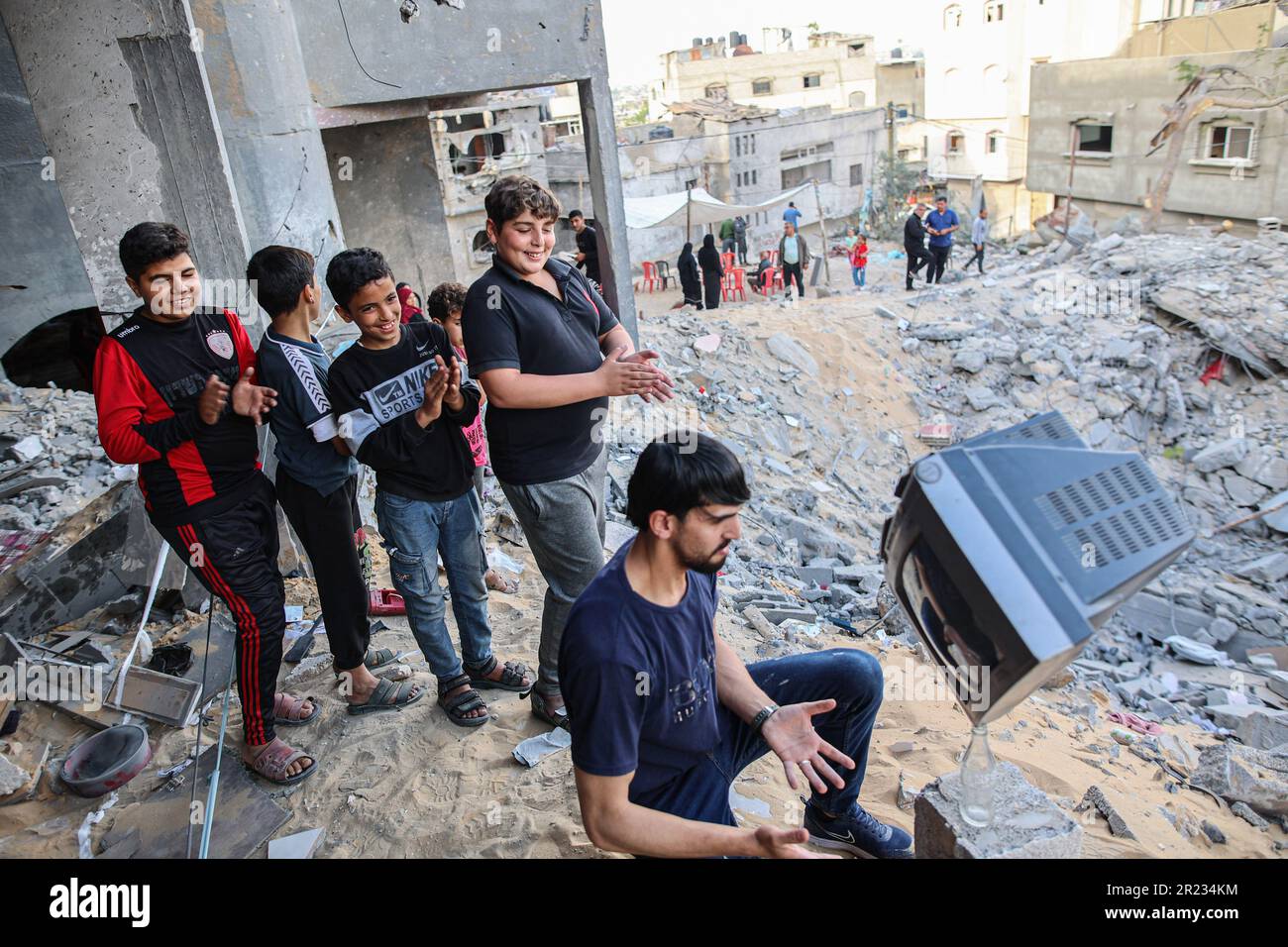 Palestinian boys smile as a Palestinian artist Mohammed Al-Shenbari ...