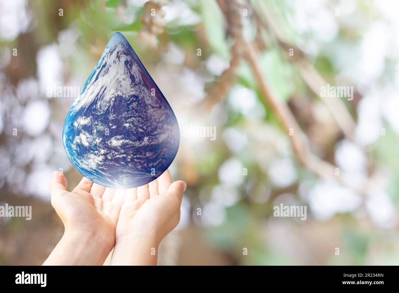 Earth in shape water drop from the top of the children hand on green ...