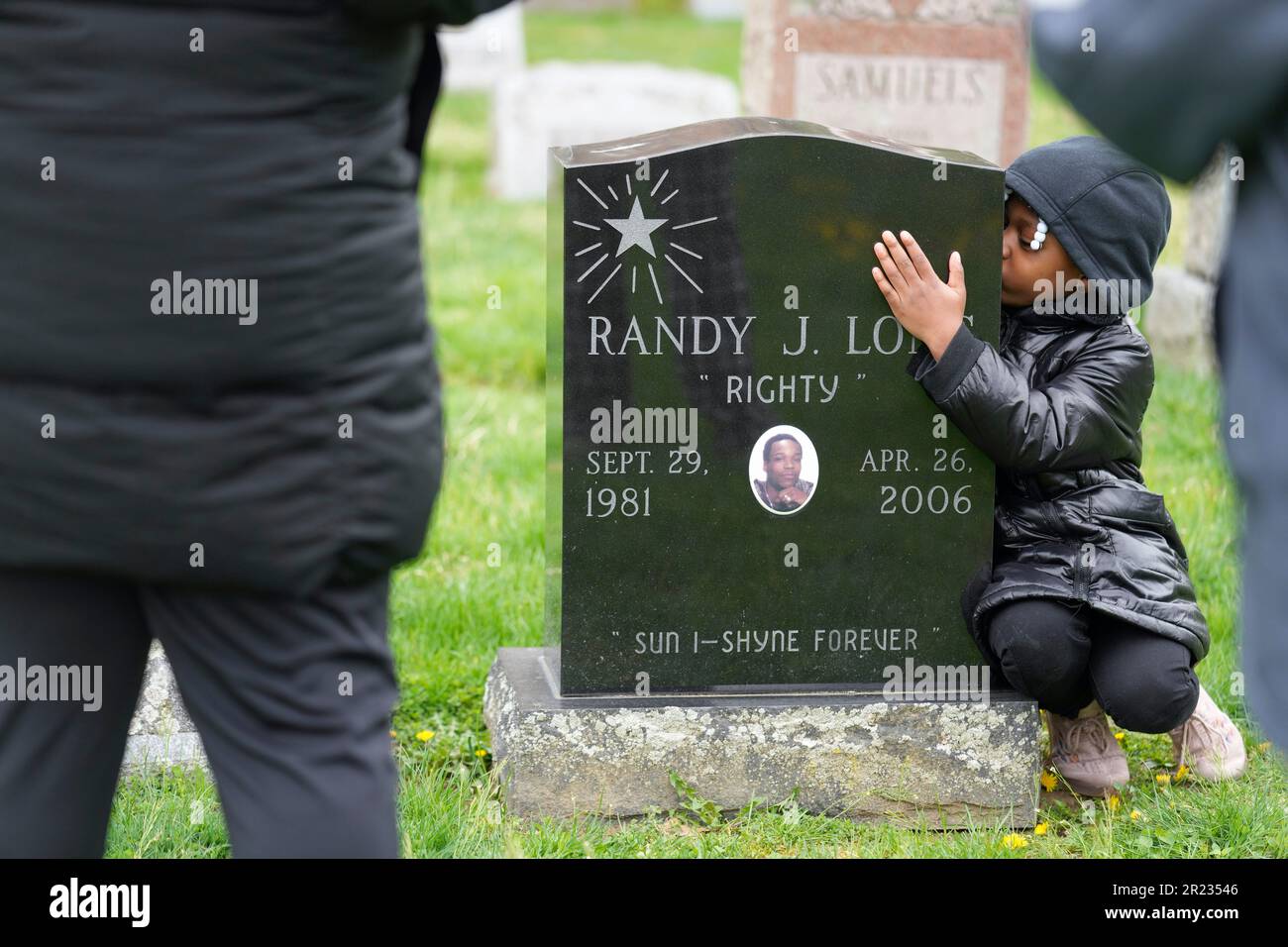 Xia'la Long kisses her uncle Randy Long's tombstone while posing for a ...