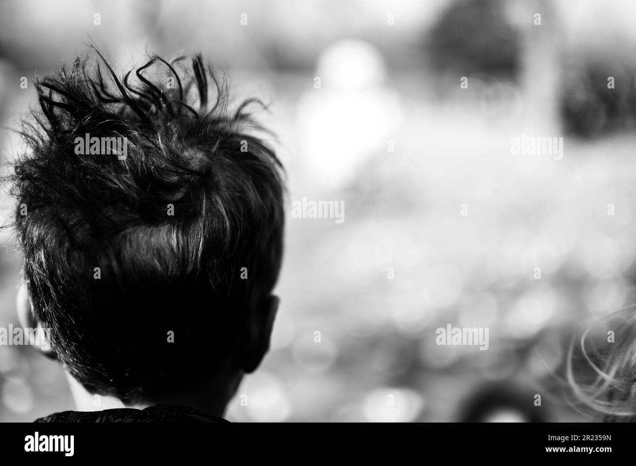 Selective focus on a single child with messy hair sticking up looking ...