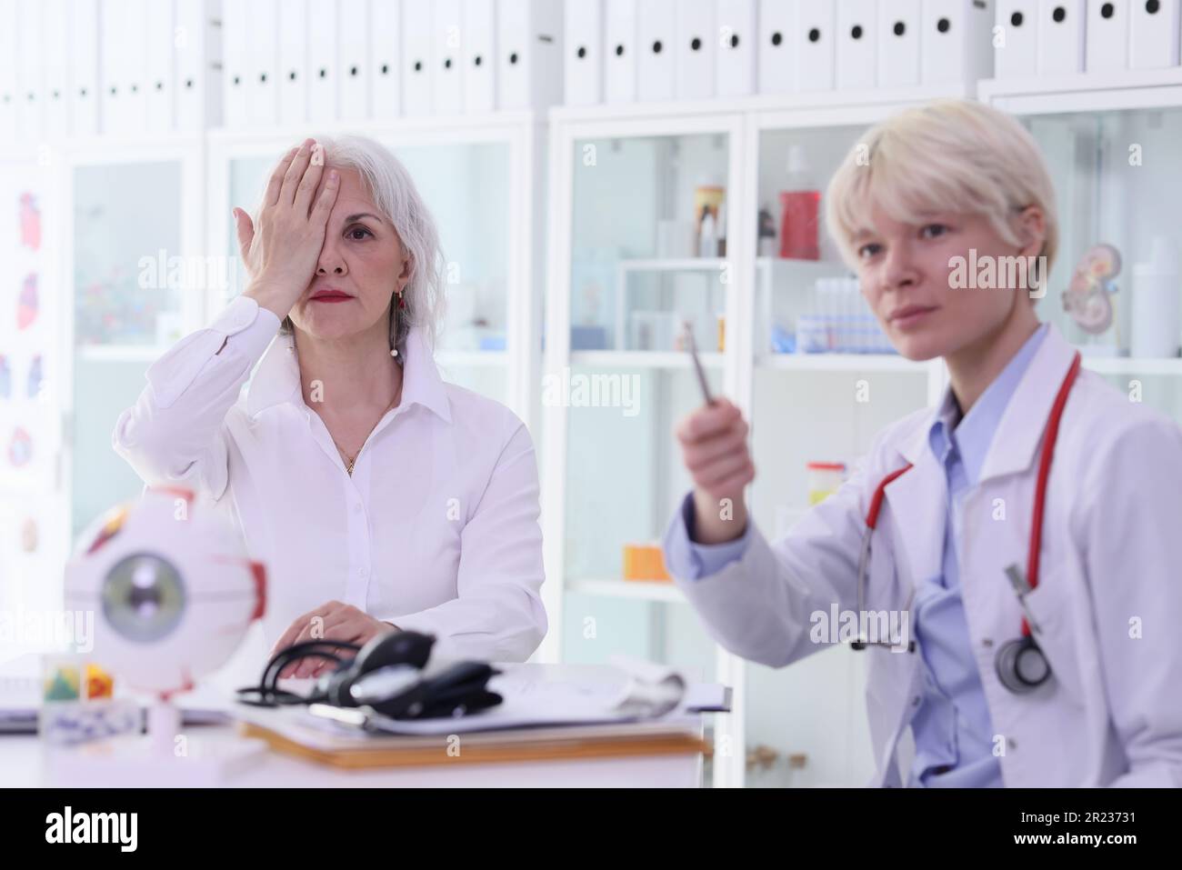 Blonde doctor shows patient letters on Snellen chart Stock Photo - Alamy