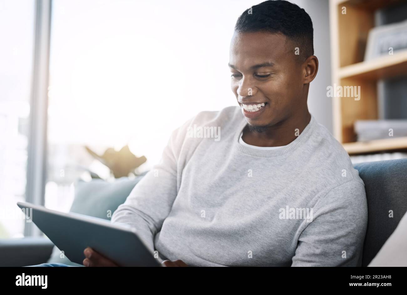 Living room, tablet and happy man on couch browsing social media meme ...