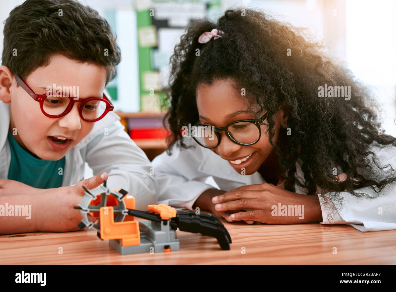 Engineering, school and kids building a robot hand together in a ...