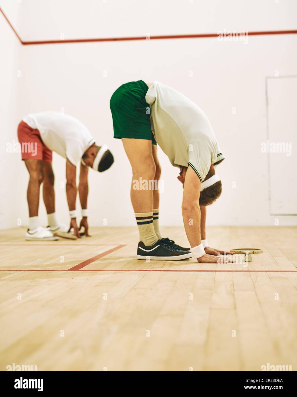 He who controls his body, controls his game. two young men stretching ...
