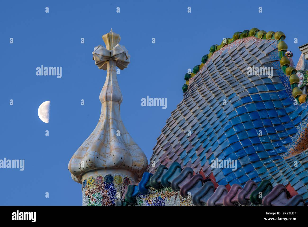 Sunrise over the roof of the Casa Batlló with the waning moon behind ...