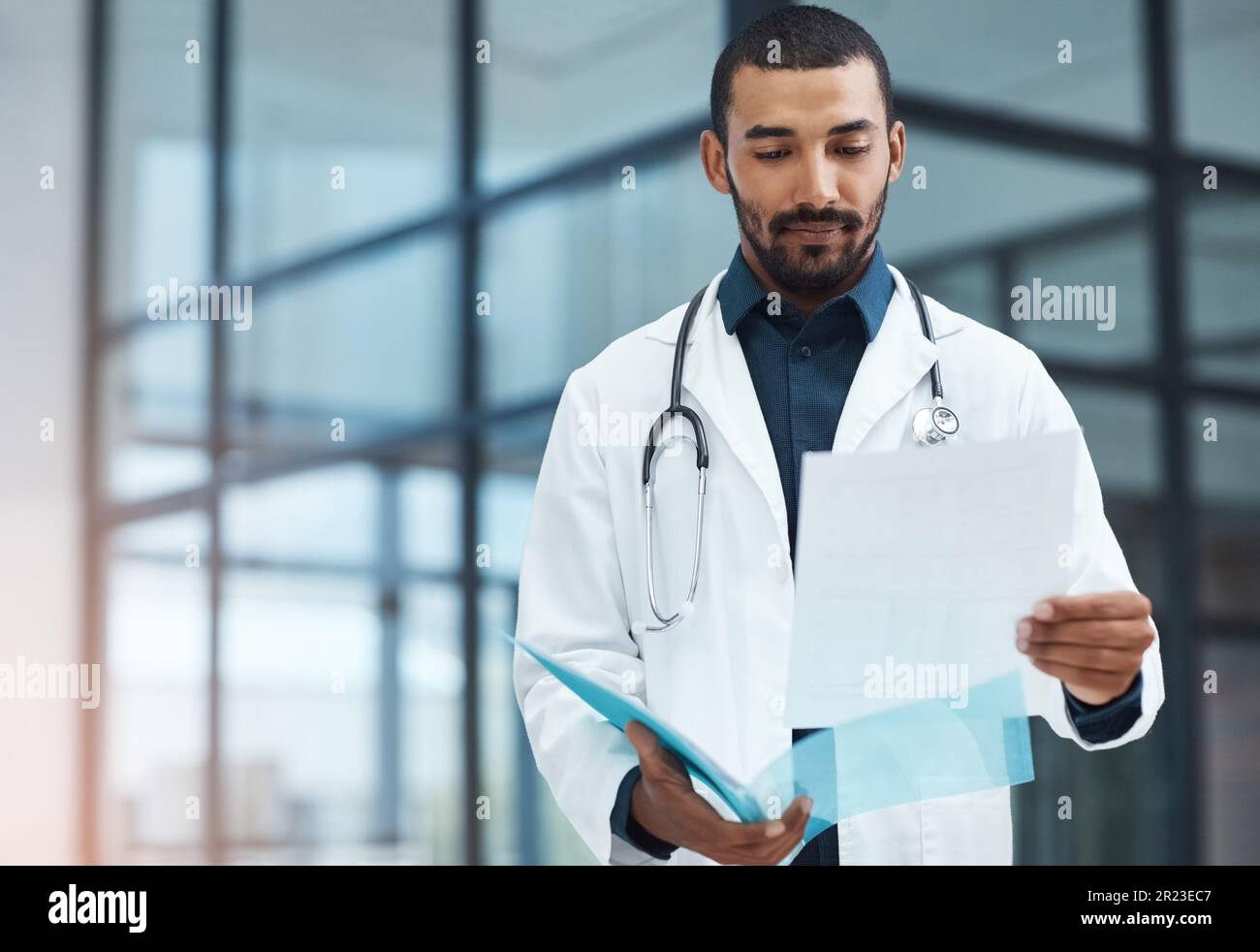Attention to detail is key. a young doctor going over the contents of a ...