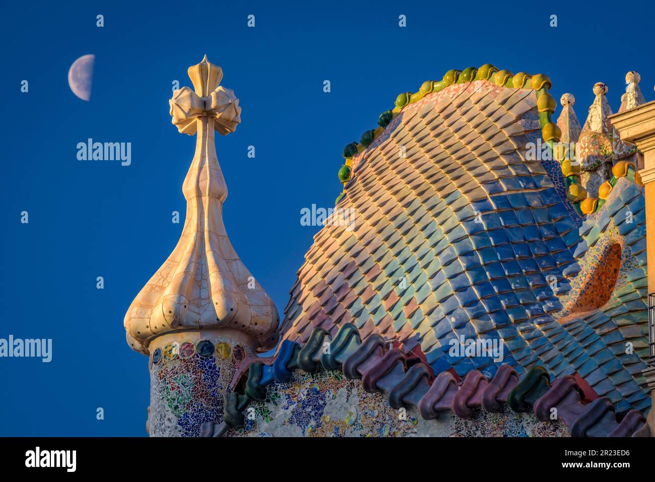 Sunrise over the roof of the Casa Batlló with the waning moon behind ...
