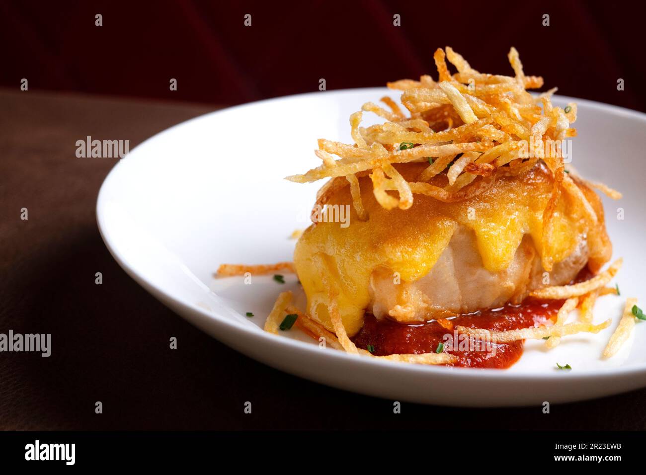 Baked cod gratin with almond allioli and topped with French fries ...