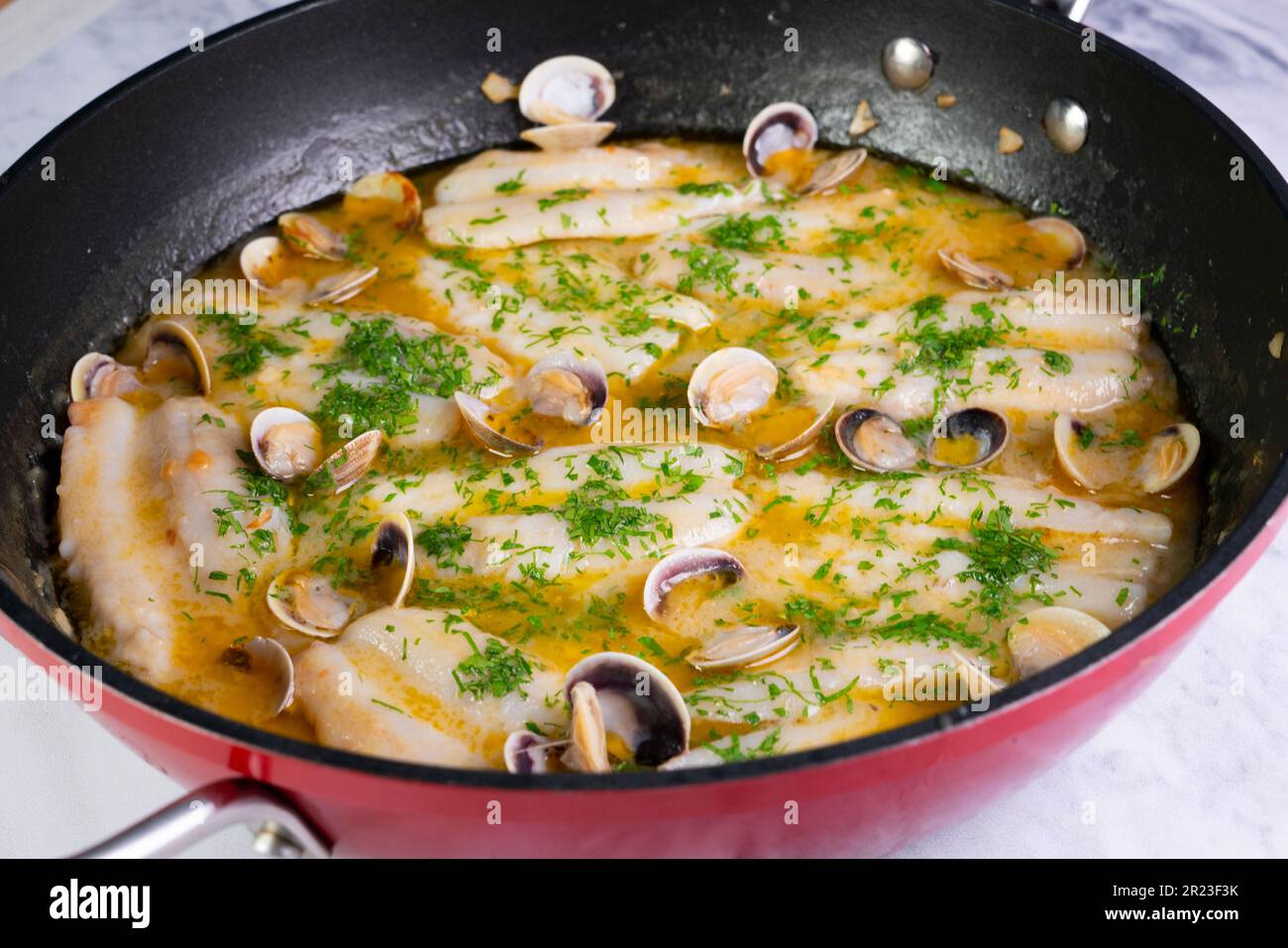 Blue whiting with green sauce. Traditional recipe from the Basque ...