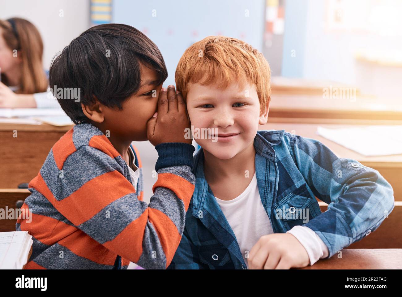 I have a secrete to tell. elementary school kid whispering into another ...