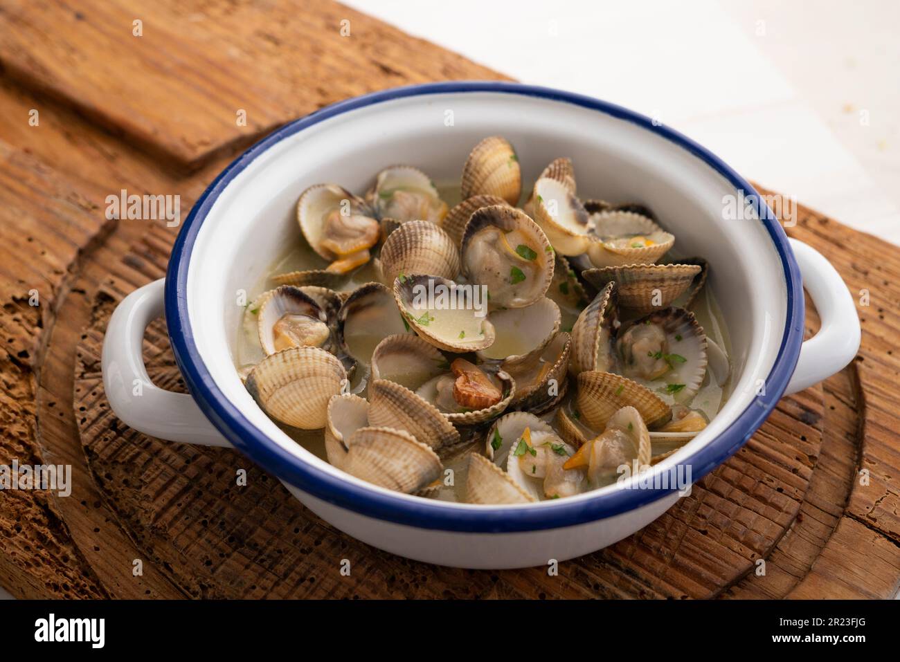 Cockles with green garlic and parsley sauce. Traditional Spanish fish ...