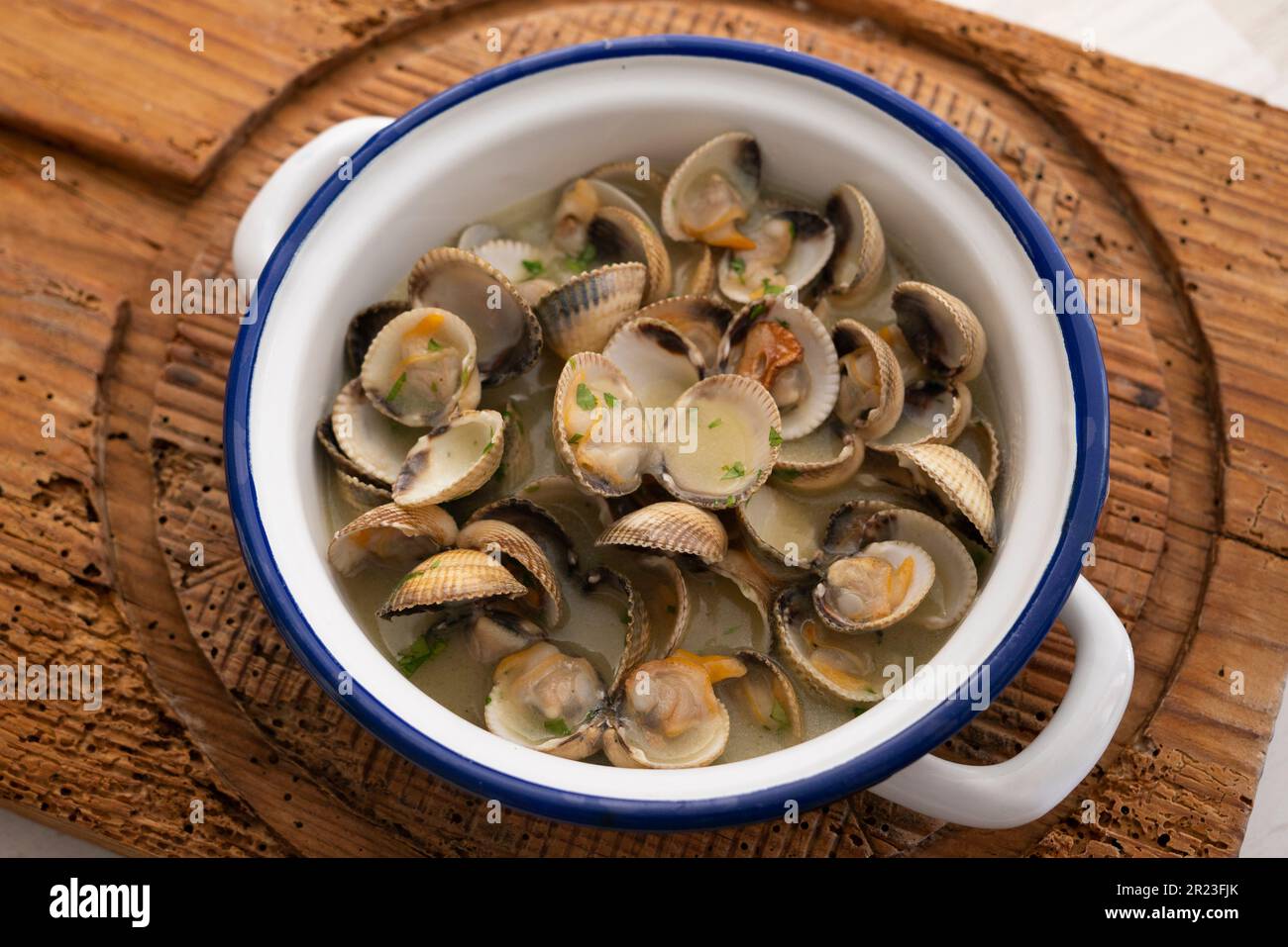 Cockles with green garlic and parsley sauce. Traditional Spanish fish ...