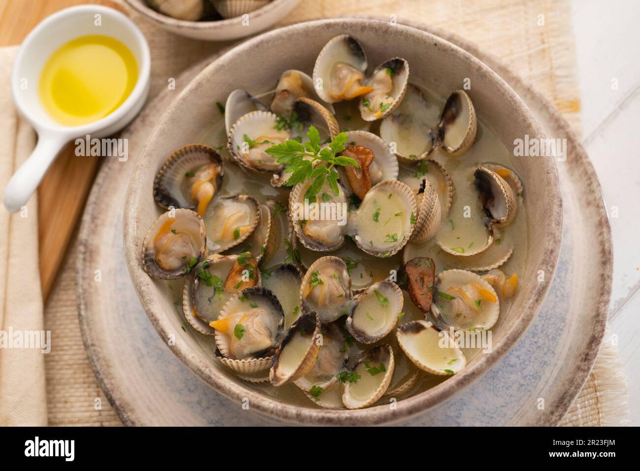 Cockles with green garlic and parsley sauce. Traditional Spanish fish ...