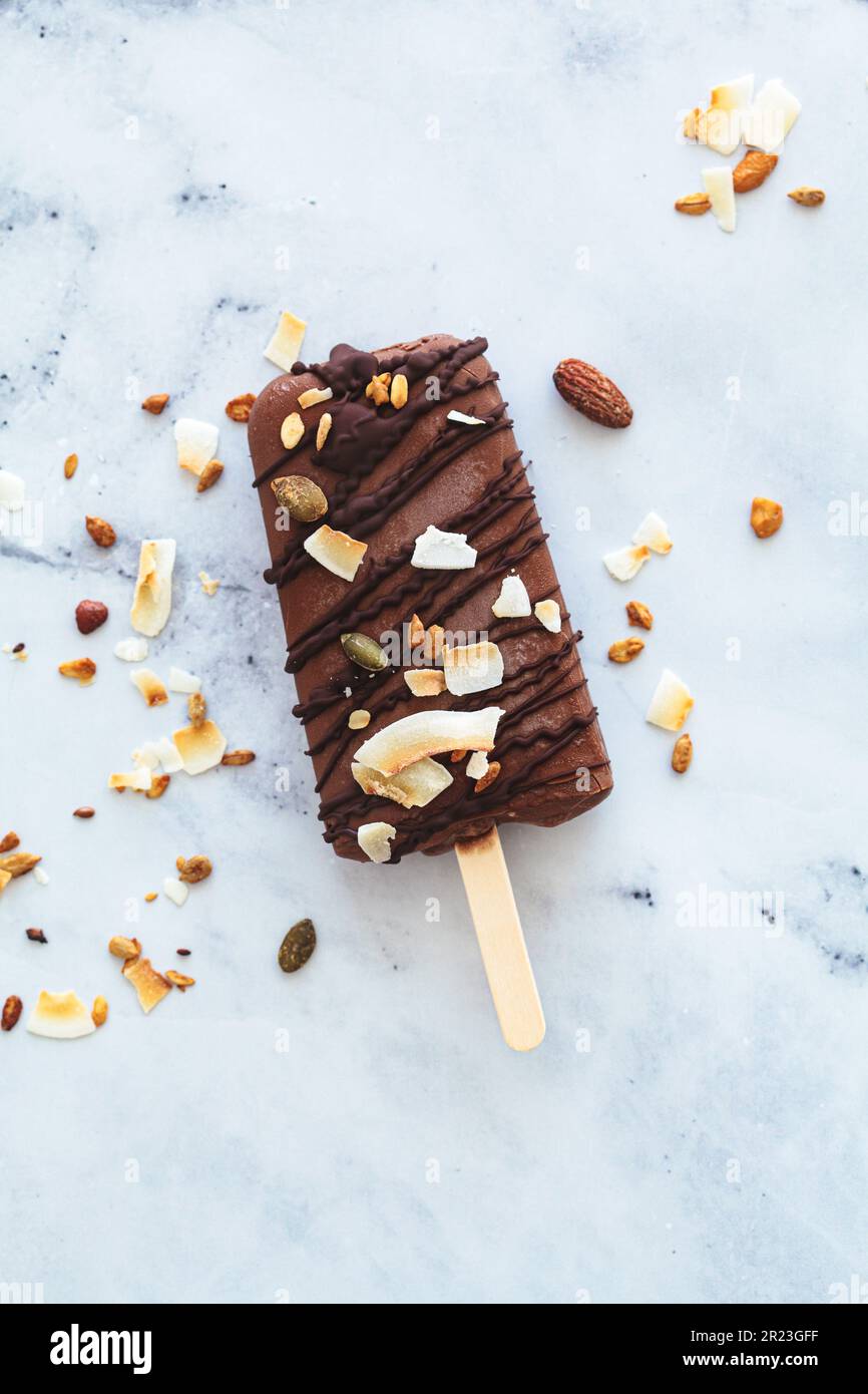 Vegan chocolate popsicle on a stick, top view. Summer dessert, plant ...
